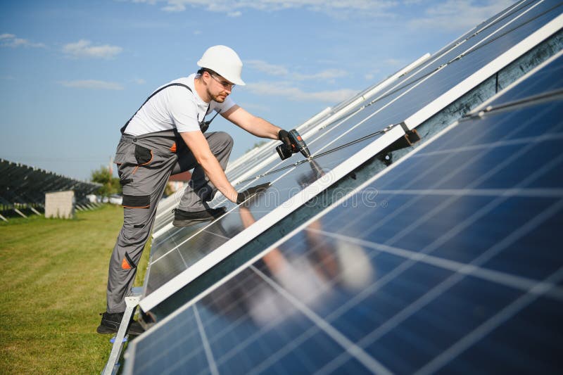 Portrait of a Worker in Uniform and White Helmet Working on Solar ...