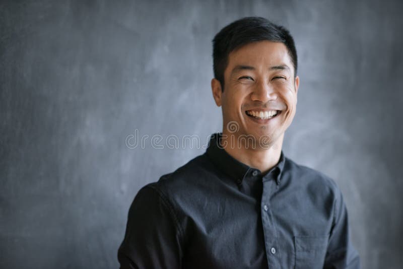 Smiling Asian Businessman Standing by a Chalkboard in an Office Stock ... Smiling Asian Businessman Standing by a Chalkboard in an Office Stock ...