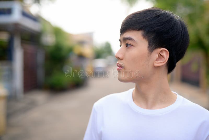 Profile View of Young Asian Man Thinking in the Streets Outdoors Stock ...