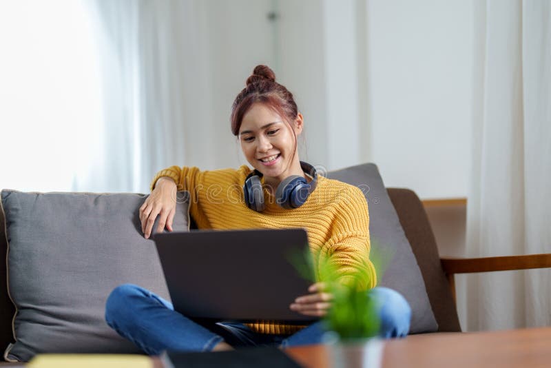 Portrait of a Young Asian Woman Using a Computer on the Sofa Stock ...