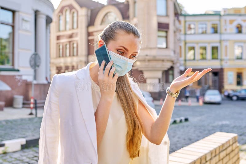 Portrait Of Young Business Woman In Medical Protective Mask Talking On