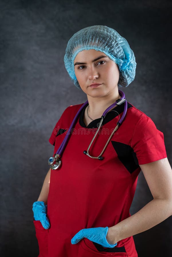 Portrait of Young Caucasian Female Nurse or Doctor Wear Red Uniform ... Portrait of Young Caucasian Female Nurse or Doctor Wear Red Uniform ...