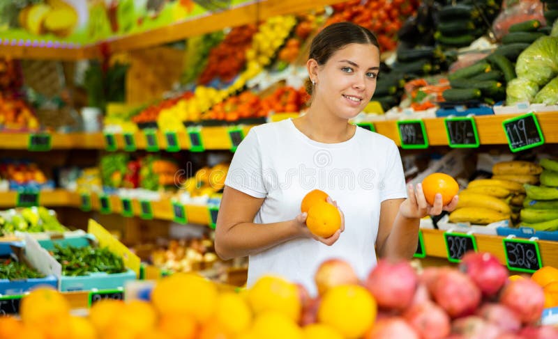 Portrait of Young Female Choosing Fresh Oranges in Store Stock Image ...