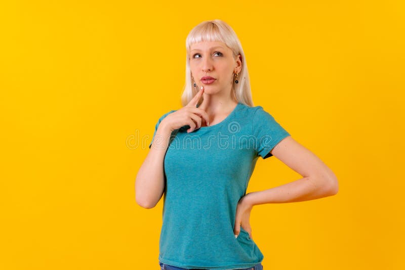 Portrait Of Young Girl In Pensive Pose Against Yellow Background Stock