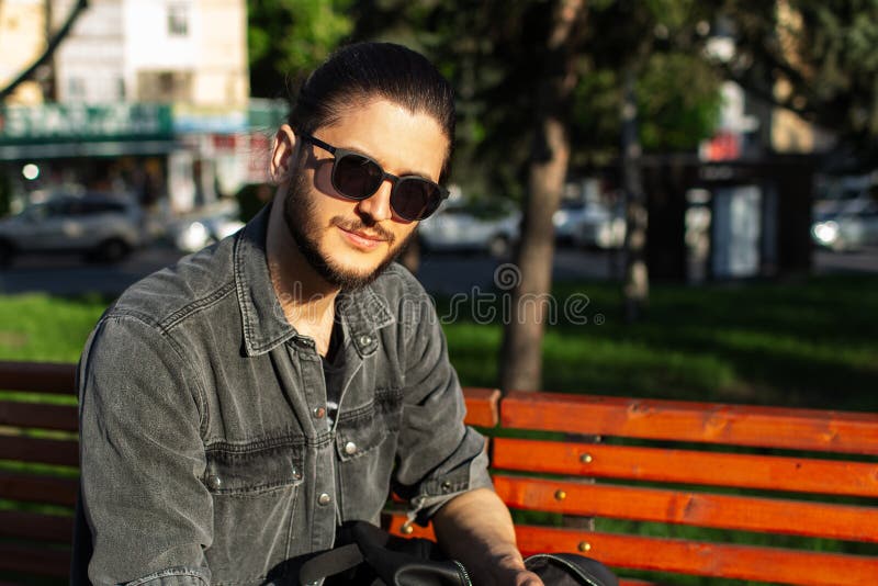 Portrait of Young Guy Sitting on Bench in the Park. Stock Image - Image ...