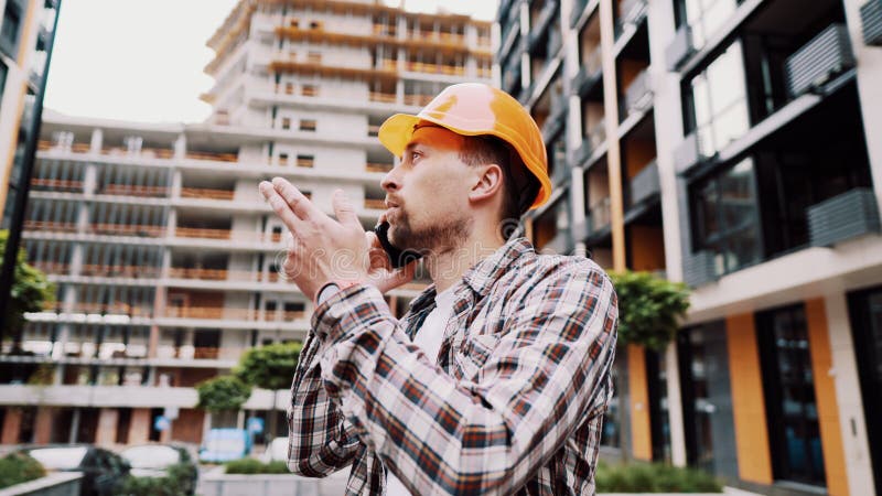 Portrait of Young Handyman Making Call while Standing at Construction ...