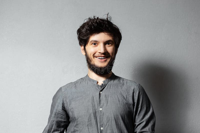 Portrait of Young Happy Man with Disheveled Hair on Grey Background ... Portrait of Young Happy Man with Disheveled Hair on Grey Background ...