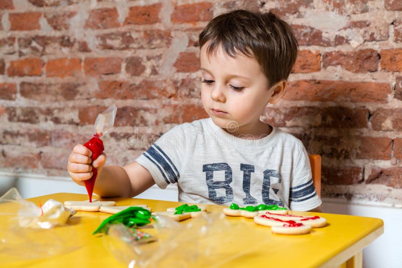 Portrait of Young Kid Making Cookies at Home Over Yellow Table ...