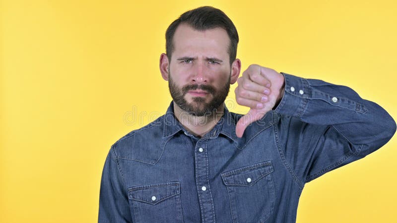 The Portrait of Young Man Doing Thumbs Down, Yellow Background Stock ...