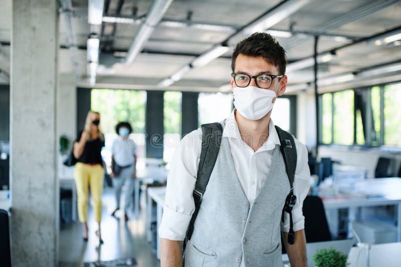 Portrait of Young Man with Face Mask Back at Work in Office after ...