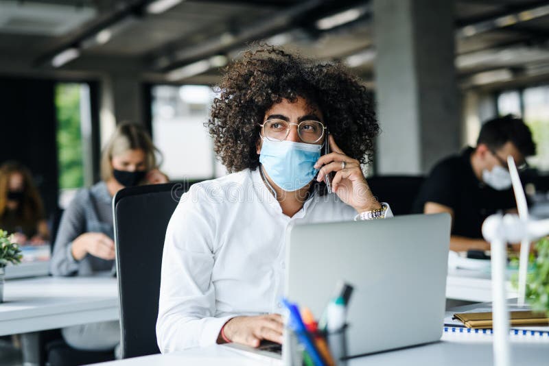 Portrait of Young Man with Face Mask Back at Work in Office after ...