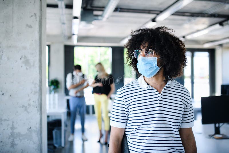Portrait of Young Man with Face Mask Back at Work in Office after ...