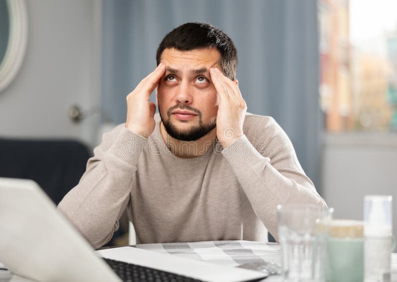 Young Man Having Headache while Sitting at Home Table with Laptop Stock ...