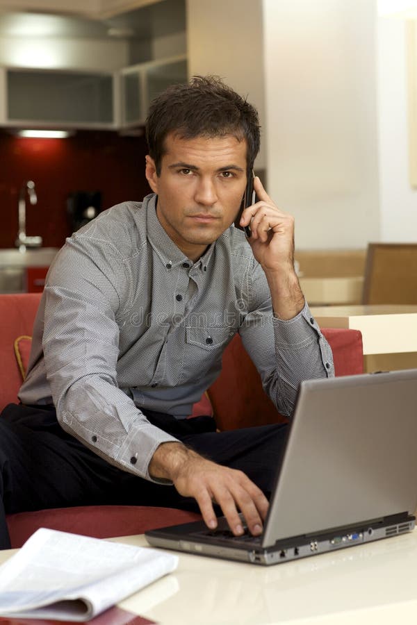 Portrait of Young Man on the Phone, Using Laptop Stock Photo - Image of ...