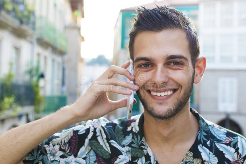 Young Man Smiling Talking on Mobile Phone in the City Stock Photo ...