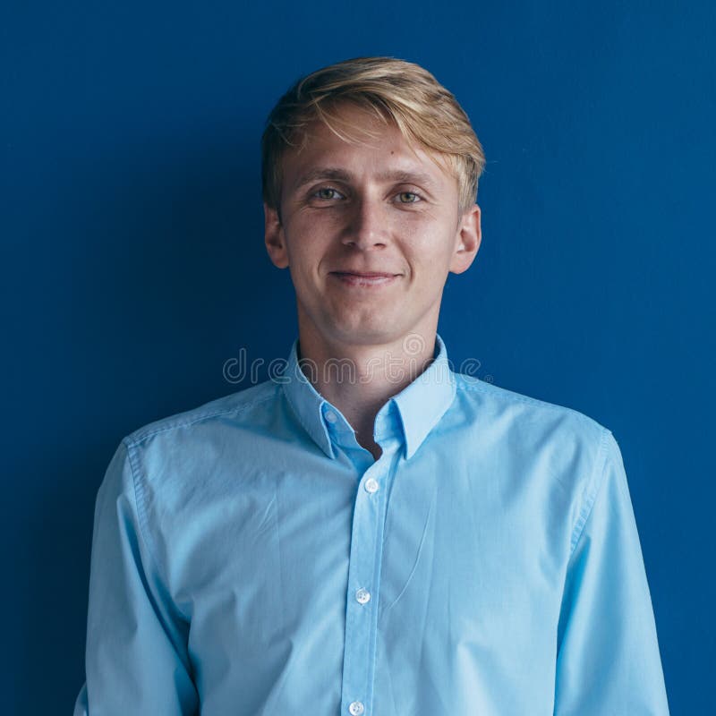 Portrait of a Young Man Standing Against Blue Background Stock Photo ...