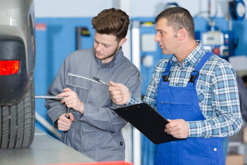 Mechanic and Apprentice Working on Car Stock Photo - Image of skill ...