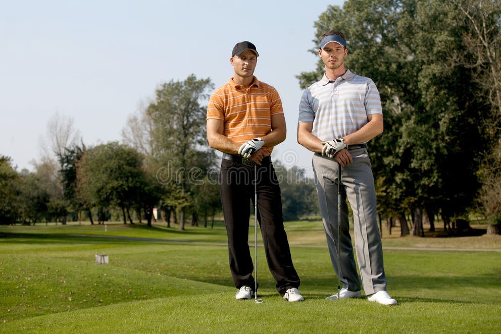 Portrait of Young Men Standing with Golf Sticks on Golf Course Stock ...