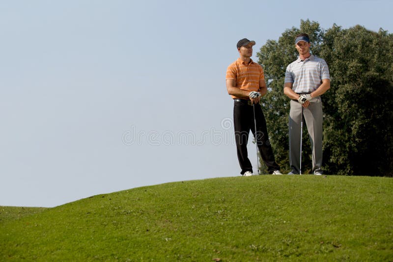 Portrait of Young Men Standing with Golf Sticks on Golf Course Stock ...