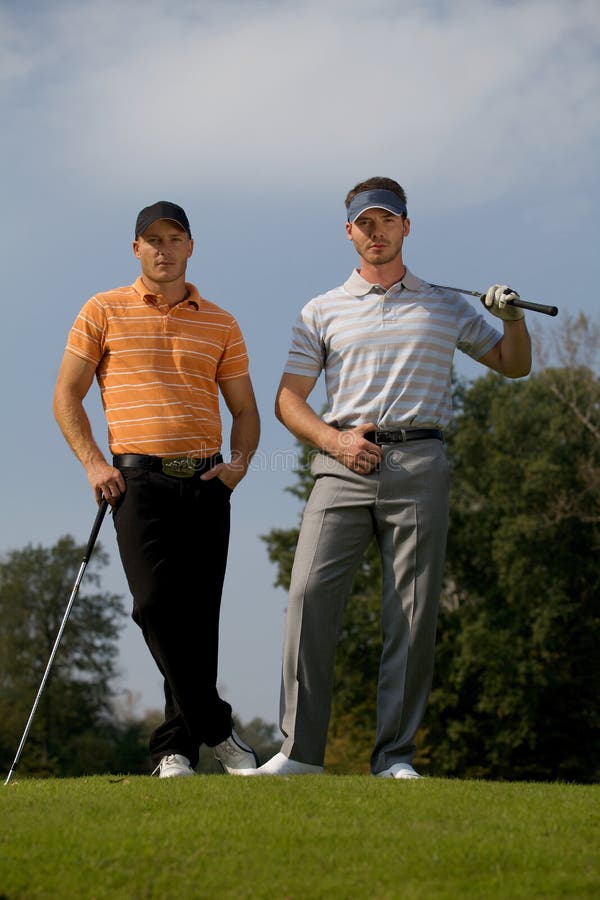 Young Men Standing in Golf Course with Sticks, Rear View Stock Photo ...