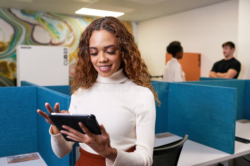 Portrait of Young Multi-ethnic Woman Using Digital Tablet in Open Plan ...