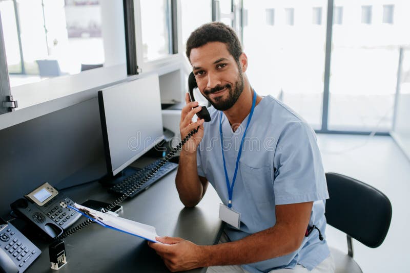 Portrait of Young Multiracial Doctor Sitting at Reception and Calling ...
