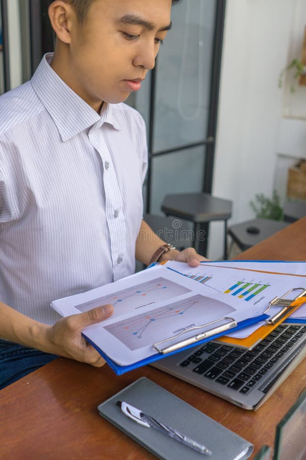 Portrait of Young Office Employee Reading Report and Document Stock ...