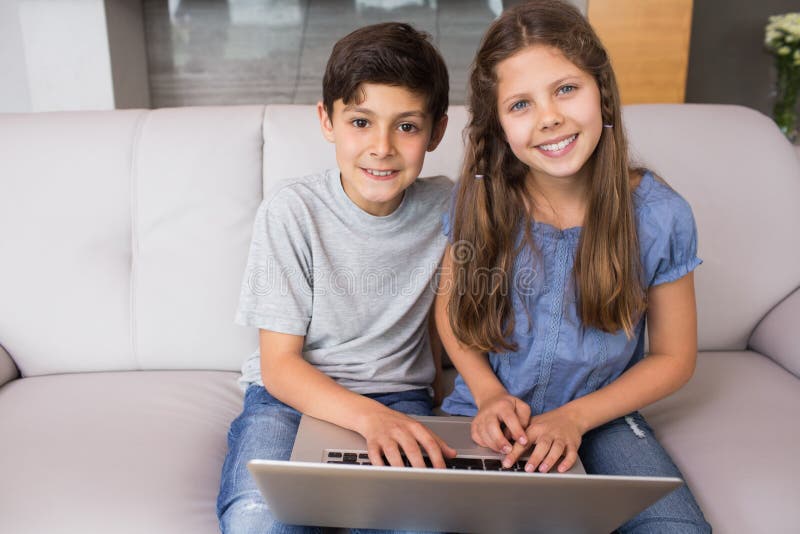 Portrait of Young Siblings Using Laptop in the Living Room Stock Photo ...