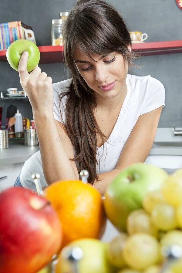 Portrait of Young Woman with Apple in Kitchen Stock Image - Image of ...