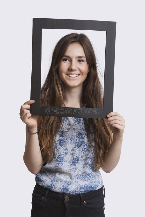 Portrait of Young Woman Smiling through Frame Over White Background ...