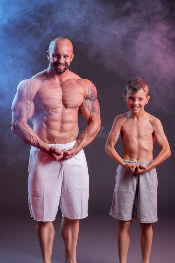 Pose Sans Chemise Dhomme Musculaire Puissant Avec Son Fils Dans Le