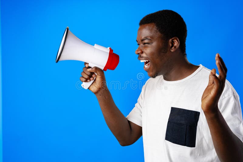 Positive African Guy Shouting with Megaphone Over Blue Background Stock ...