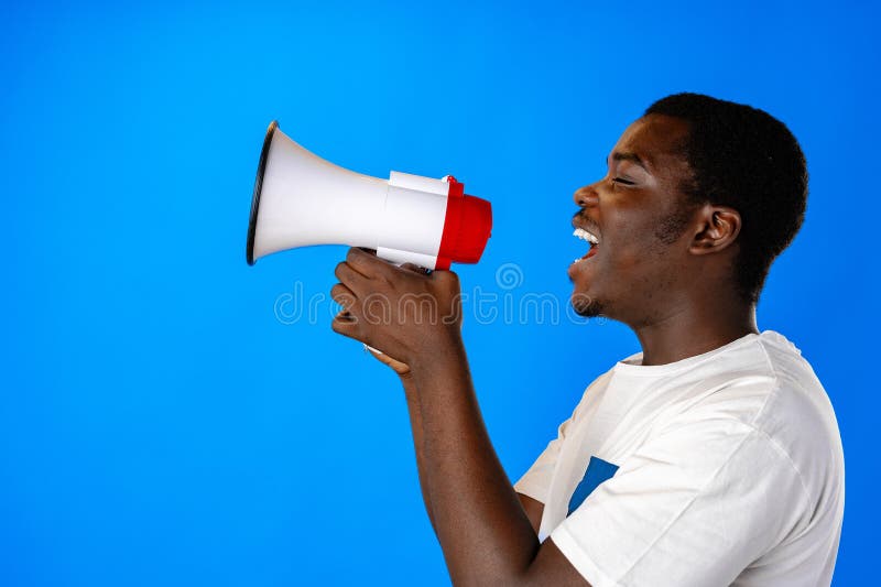 Positive African Guy Shouting with Megaphone Over Blue Background Stock ...