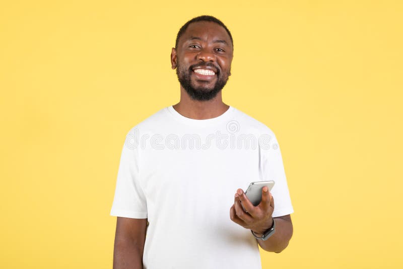 Positive Black Guy Using Smartphone Texting Standing on Yellow ...
