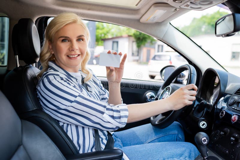 Positive Blonde Driver Holding License in Stock Photo - Image of ...
