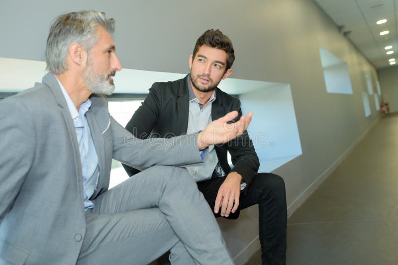 Positive Businessmen Talking in Corridor Stock Image - Image of ...