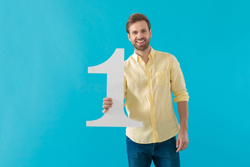 Positive Casual Man Smiling and Holding a Number One Stock Image ...