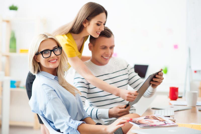 Positive Colleagues Discussing Project Stock Photo - Image of table ...