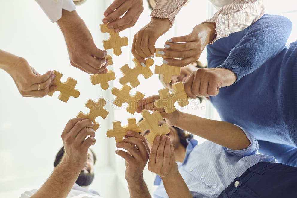 Positive Company Workers Playing with Jigsaw Puzzle during Team ...