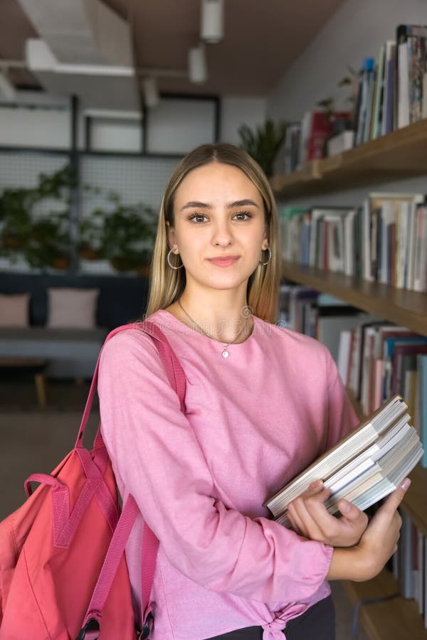 Positive Confident Student Girl Holding Stack of Books at Bookshelves ...