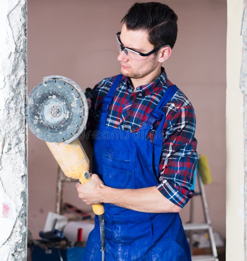 Positive Construction Worker Cutting Concrete Wall by Using Handheld ...