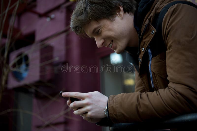 Positive Cute Guy is Using His Smart Device Stock Photo - Image of ...
