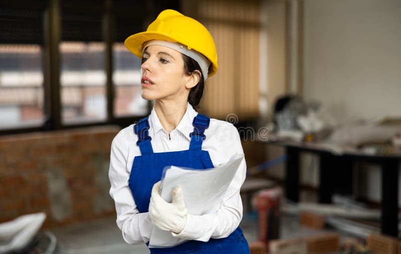 Positive Female Civil Engineer Taking Notes while Checking Indoor ...