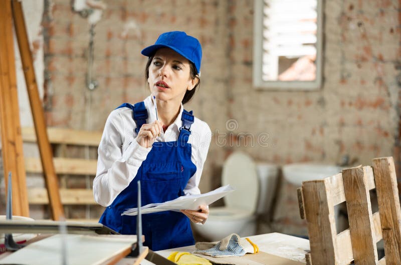 Positive Female Civil Engineer Taking Notes while Checking Indoor ...