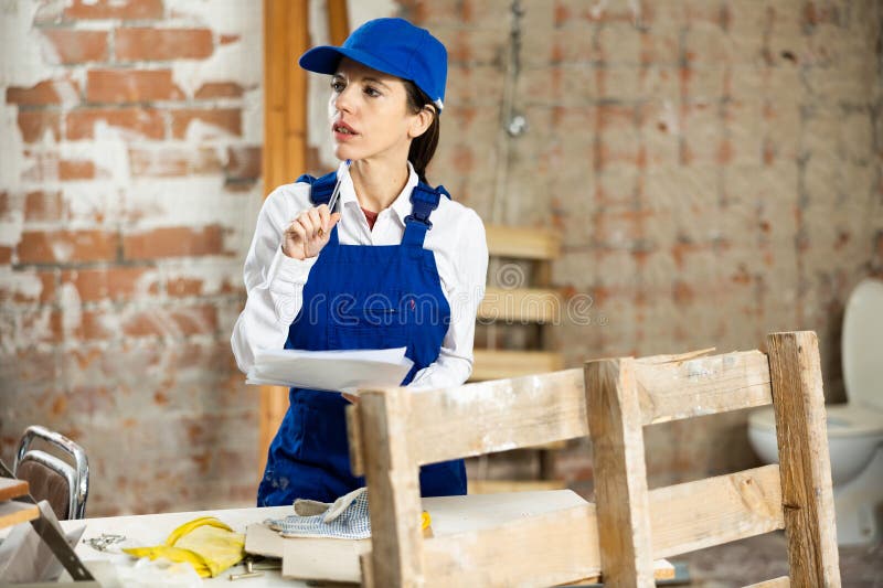 Positive Female Civil Engineer Taking Notes while Checking Indoor ...