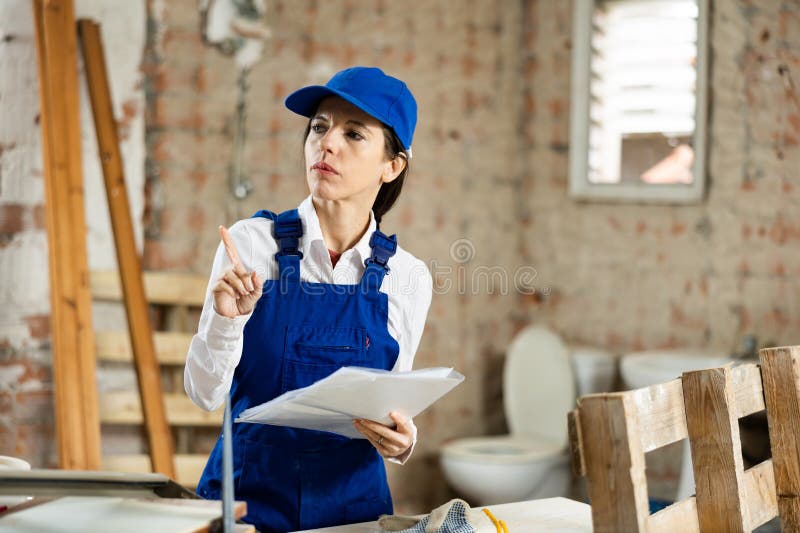 Positive Female Civil Engineer Taking Notes while Checking Indoor ...