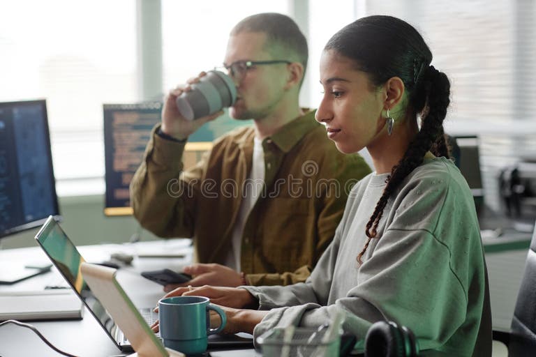 Positive Female Programmer Using Laptop for Coding while Working Next ...