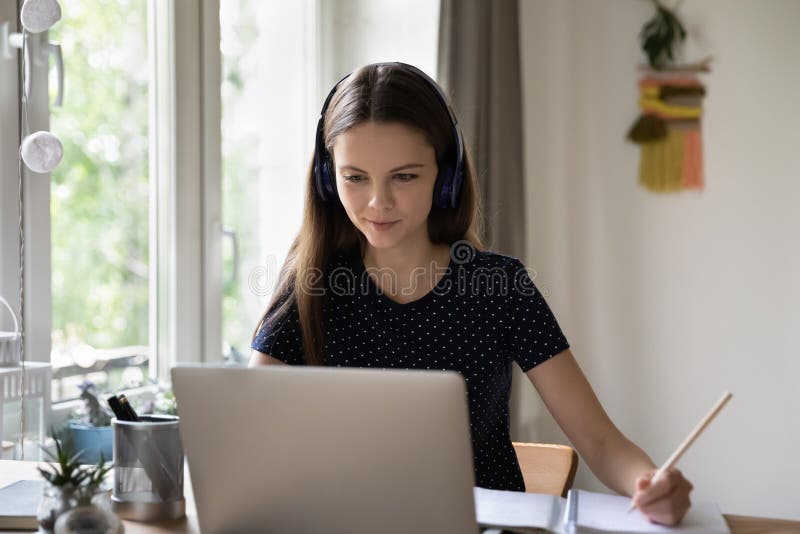Positive Focused Student Girl in Headphones Studying at Home Stock ...