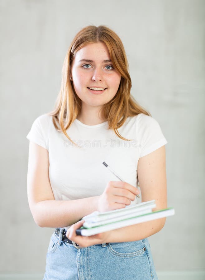 Positive Girl Student Makes Notes in Notebook. Education in High School ...