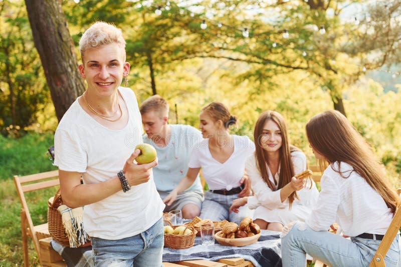 Positive Guy with Apple Standing in Front of People. Group of Young ...